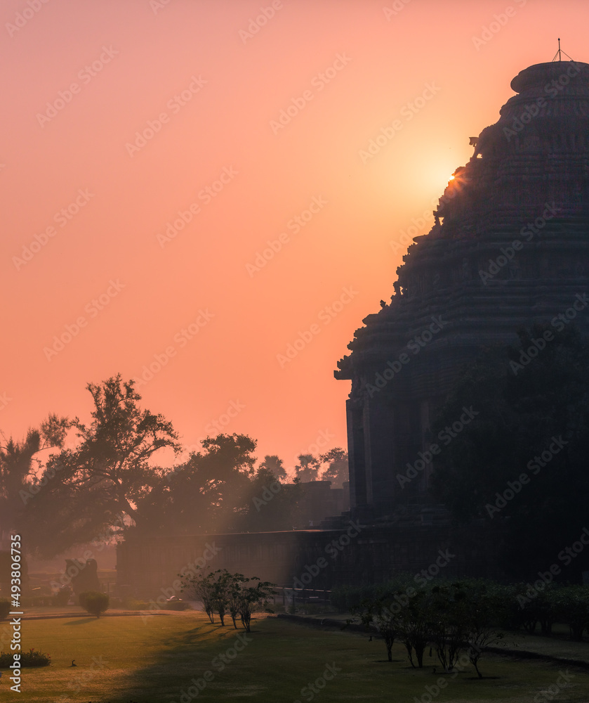 Silhouette of an 800 year old ancient temple as the sun rays emerge ...