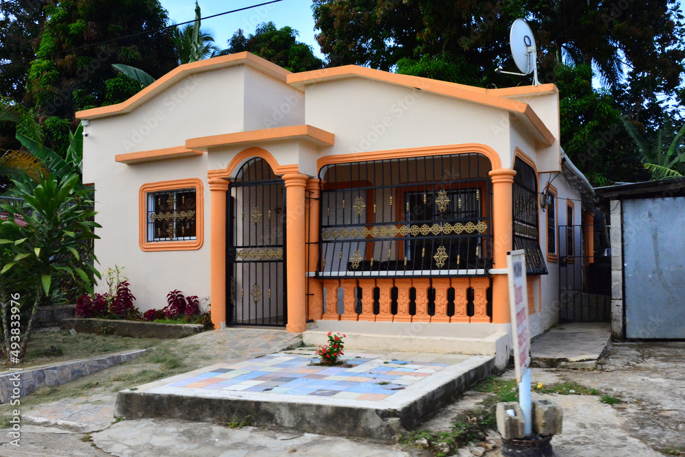 Colorful traditional dwelling, house surrounded in green vegetation in Samana Peninsula, in ...