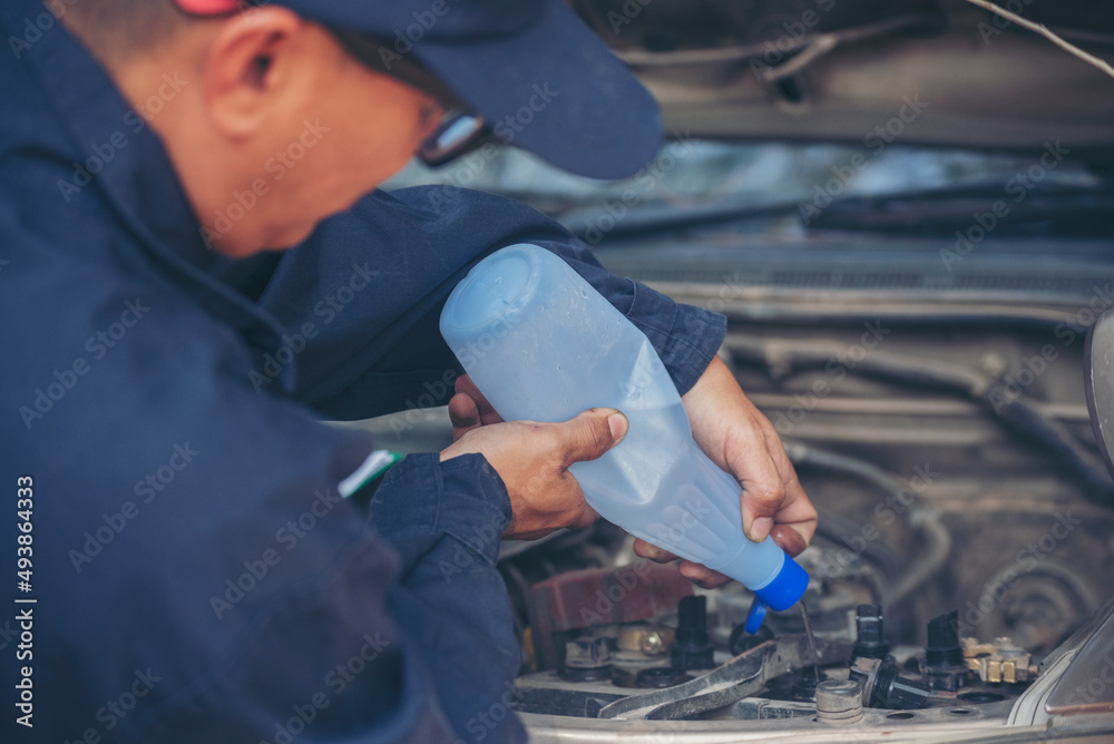 Car Mechanic man hands pouring Deionized purified Distilled water for ...