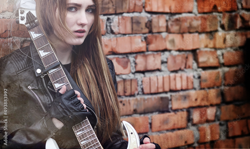 Foto de Beautiful young girl rocker with electric guitar. A rock ...