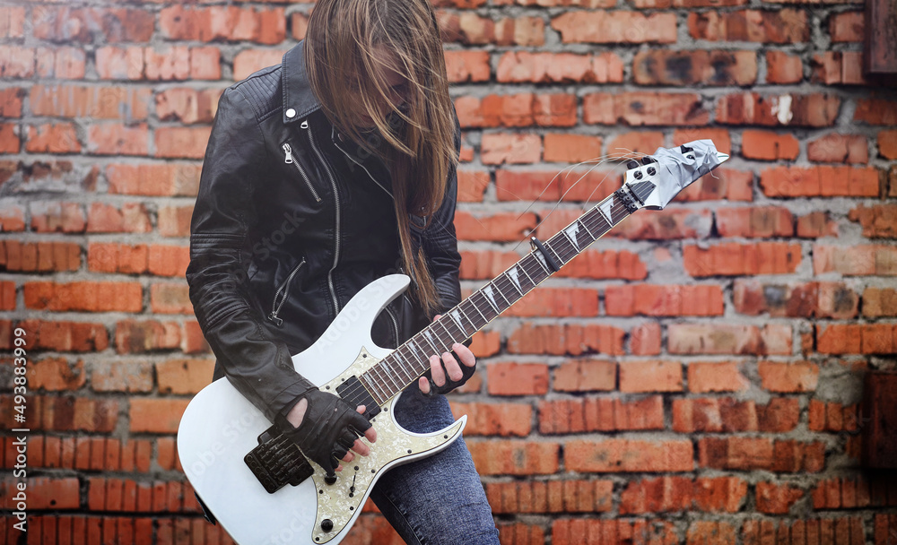 Foto de Beautiful young girl rocker with electric guitar. A rock ...