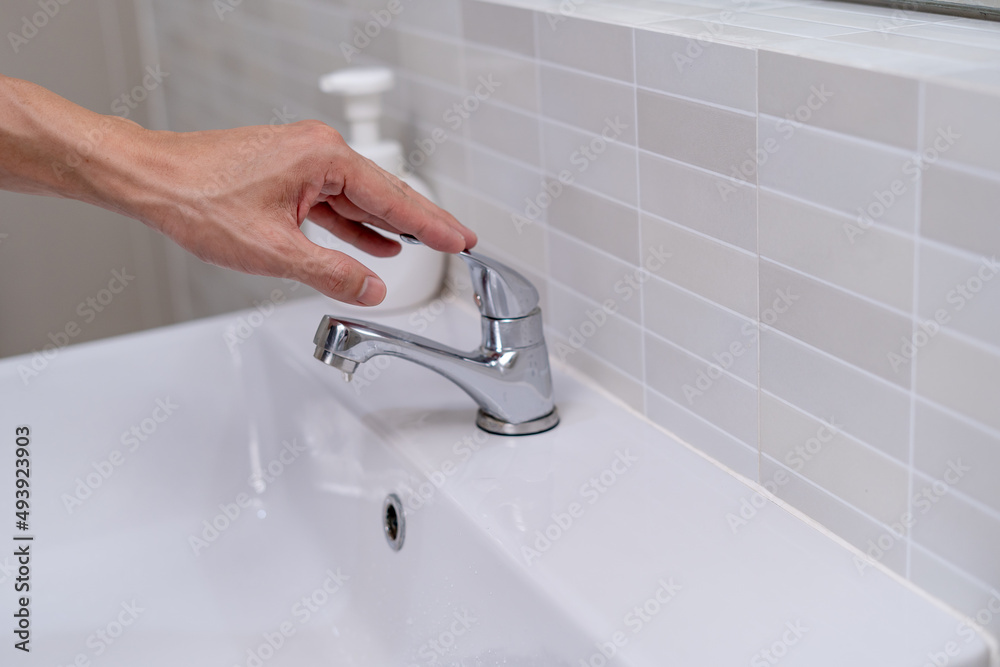 The faucet in the bathroom with running water. Man keeps turning off ...