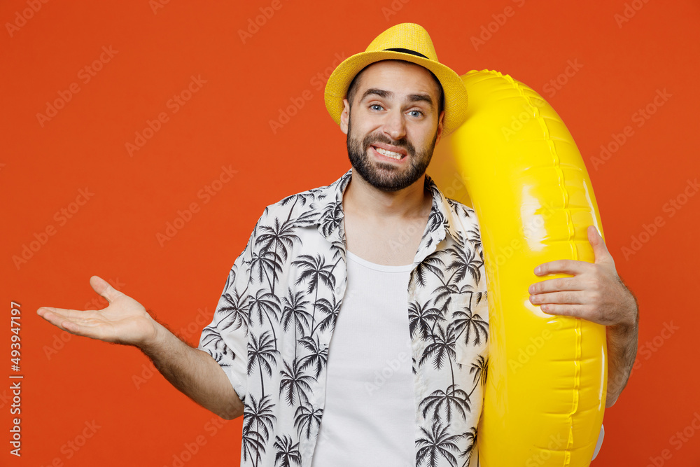 Young tourist man wear beach shirt hat hold inflatable ring spread ...