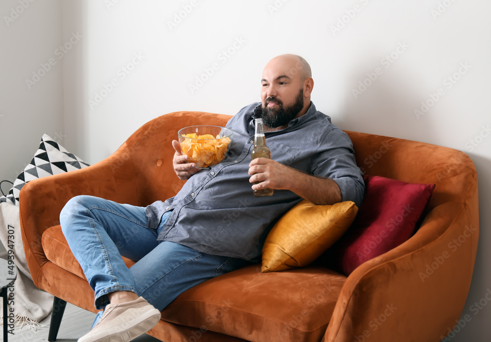 Lazy man drinking beer and eating chips at home Stock Photo | Adobe Stock