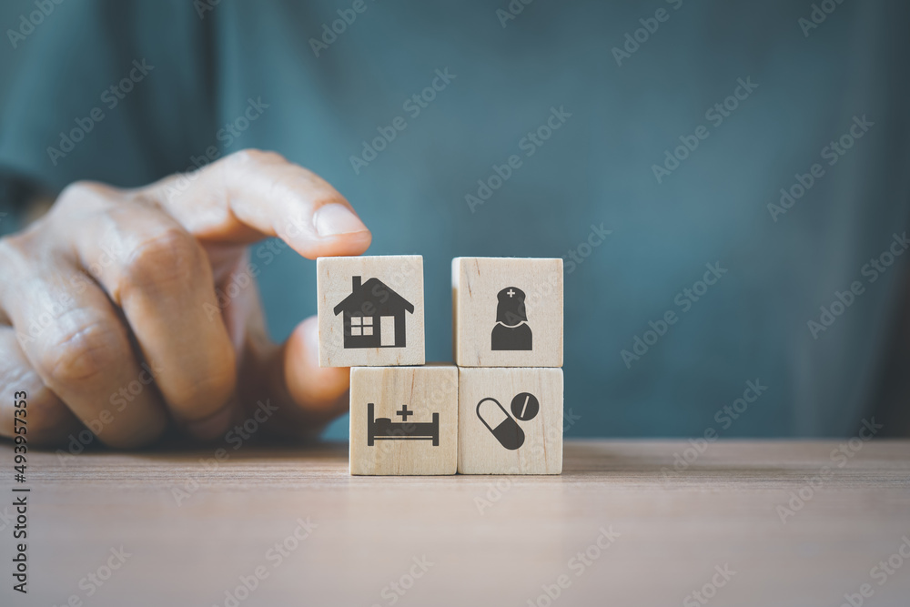 senior woman's hand completed square wooden shape with home, nurse, bed ...