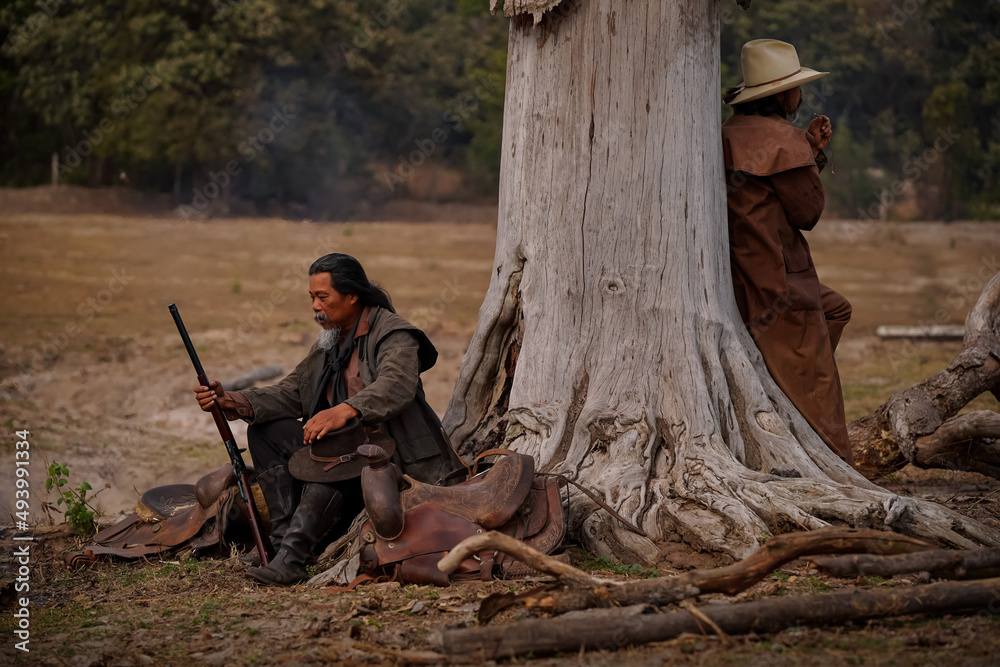 Vintage action shot of a cowboy man in a field in the soft morning sun ...