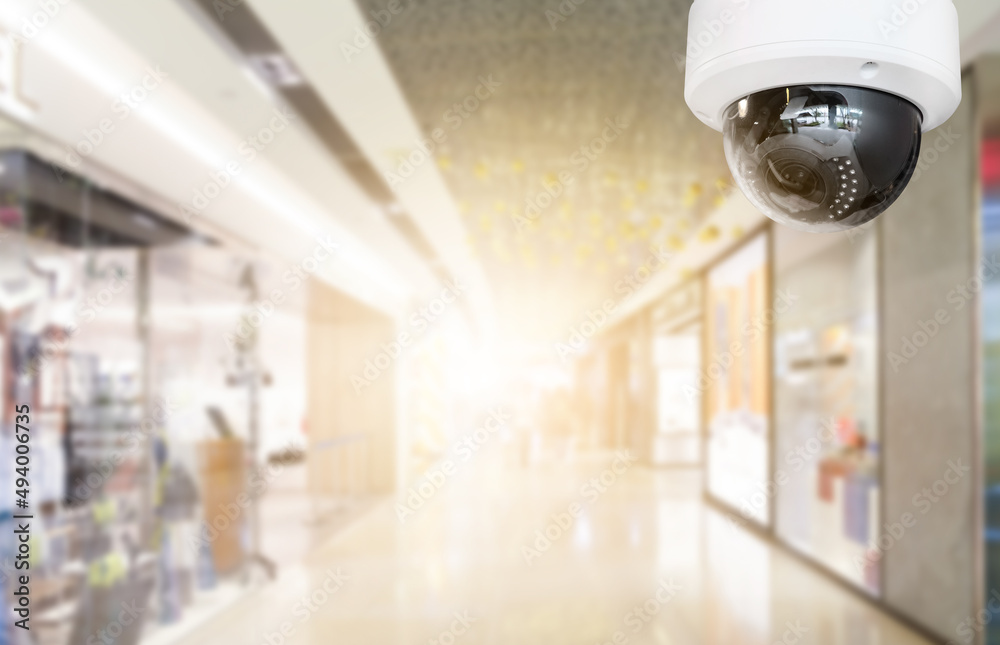 Modern public CCTV camera with blur interior shopping mall background ...
