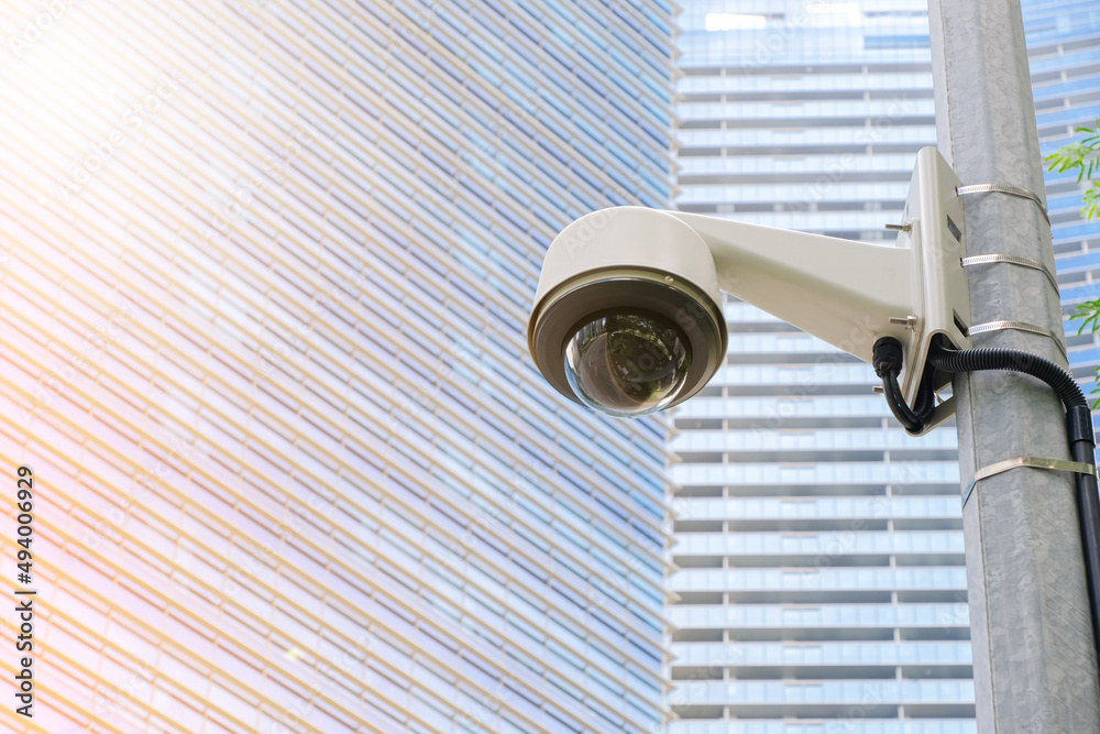 Modern public CCTV camera on electric pole with blur building ...