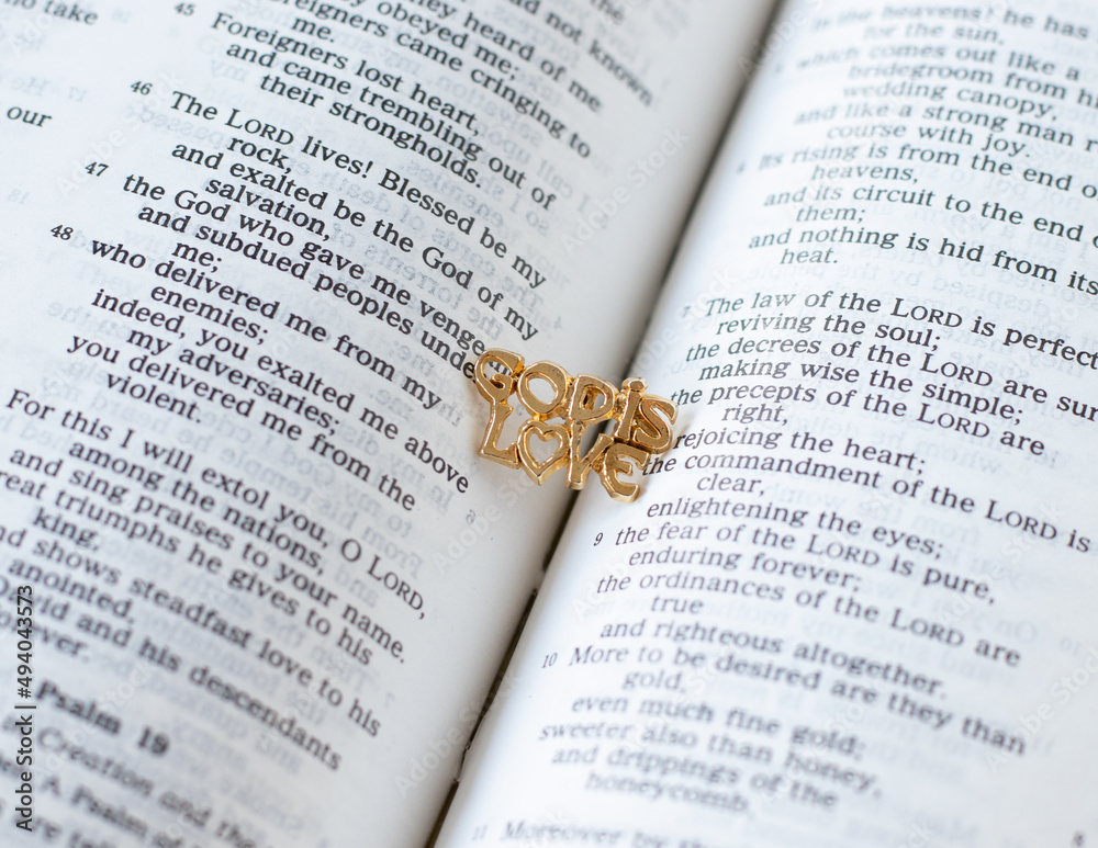 God is love, text quote written with golden letters on an open ...