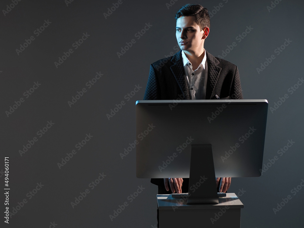 Man at computer. Businessman stands next to computer. Manager is typing ...