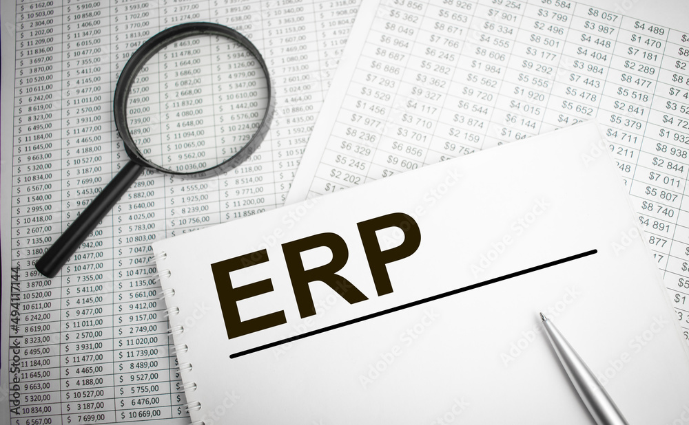 enterprise resource planning (ERP). text on white paper over torn paper ...