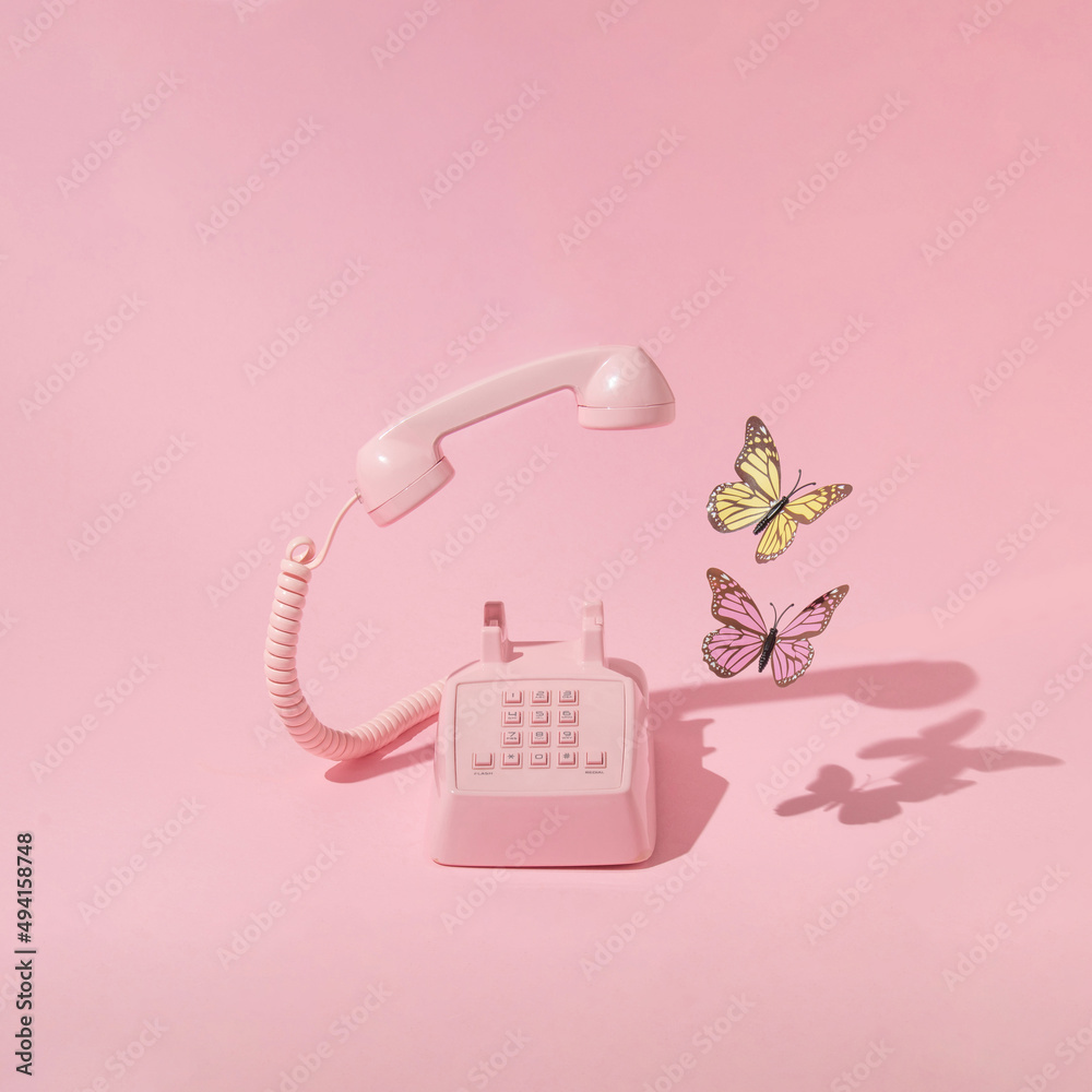 Spring creative layout with pink retro phone with colorful butterflies ...