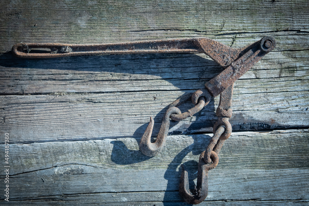 Rusty old chain binder on a slab of barn board from an abandoned farm ...