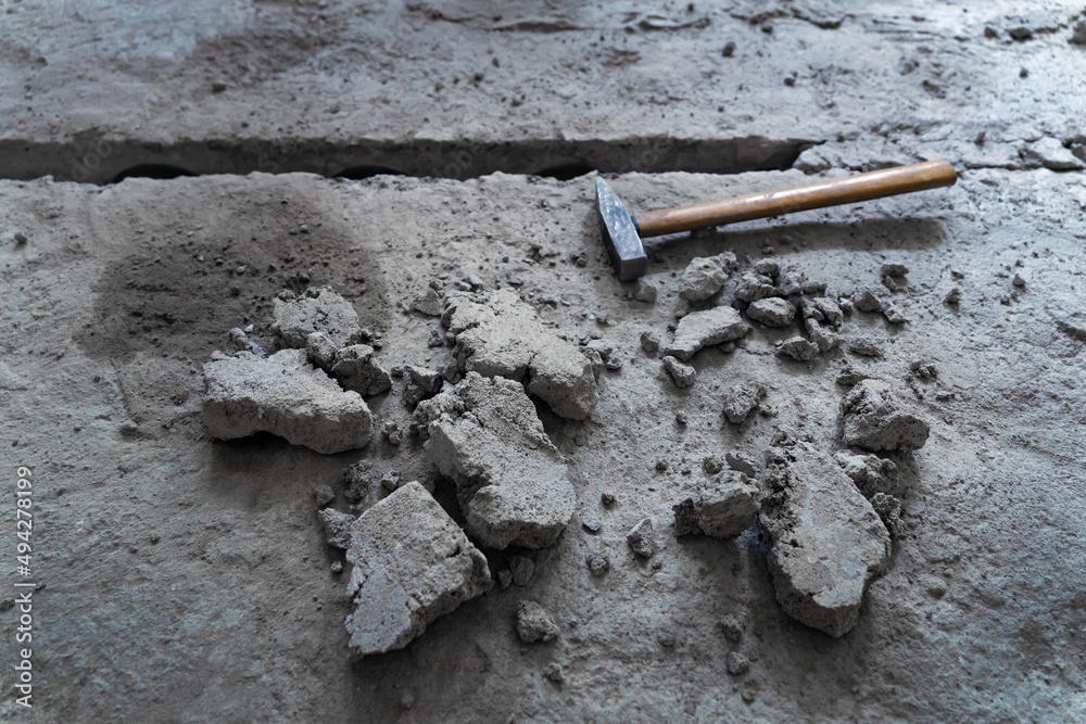 Dismantling floor in apartment. Clearing seam between concrete slabs ...