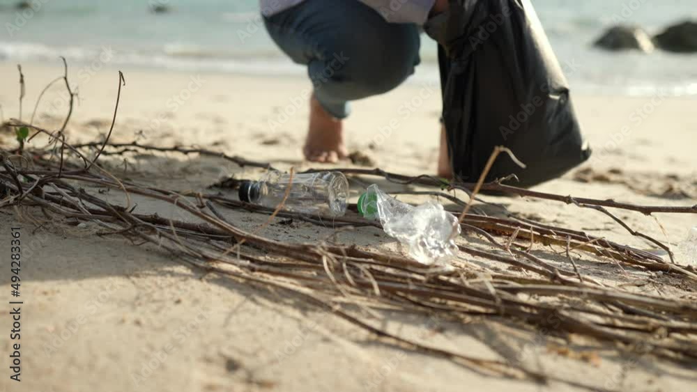 Close up woman hand pick up the plastic bottle on the beach. Female ...
