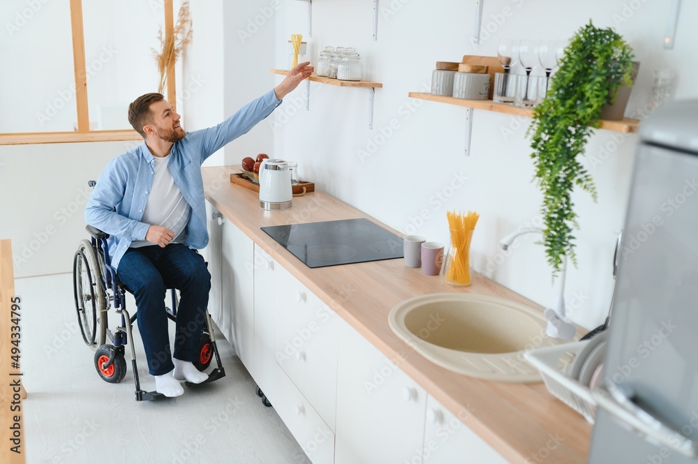 Disabled Young Man in Wheelchair Preparing Food In Kitchen Stock Photo ...