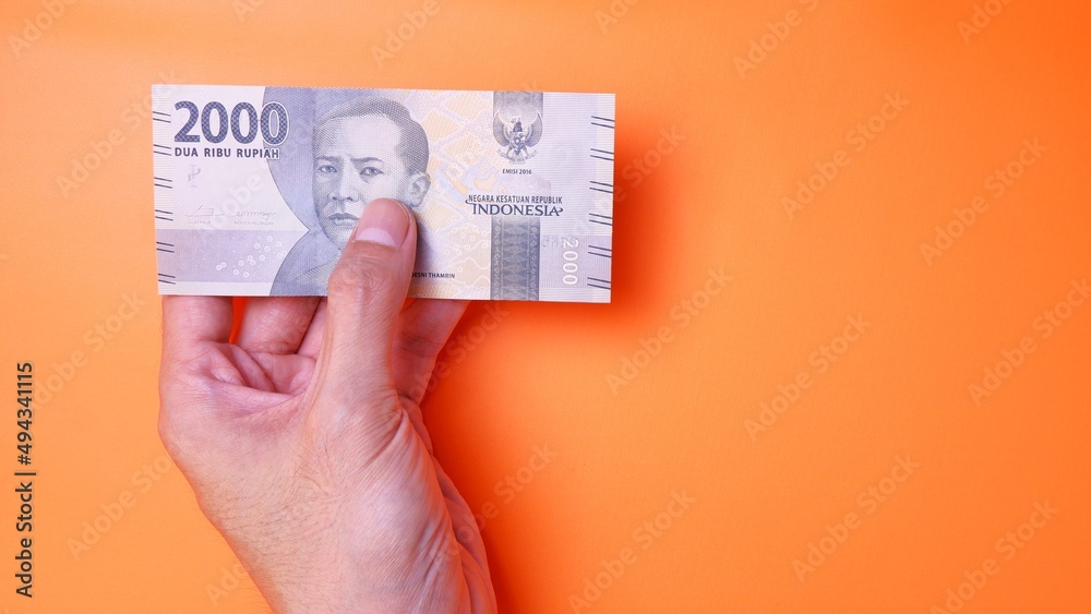 Indonesian Rupiah the official currency of Indonesia. Man's hand is ...