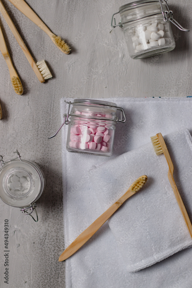 White and pink toothpastes, in transparent glass bottles, with bamboo ...
