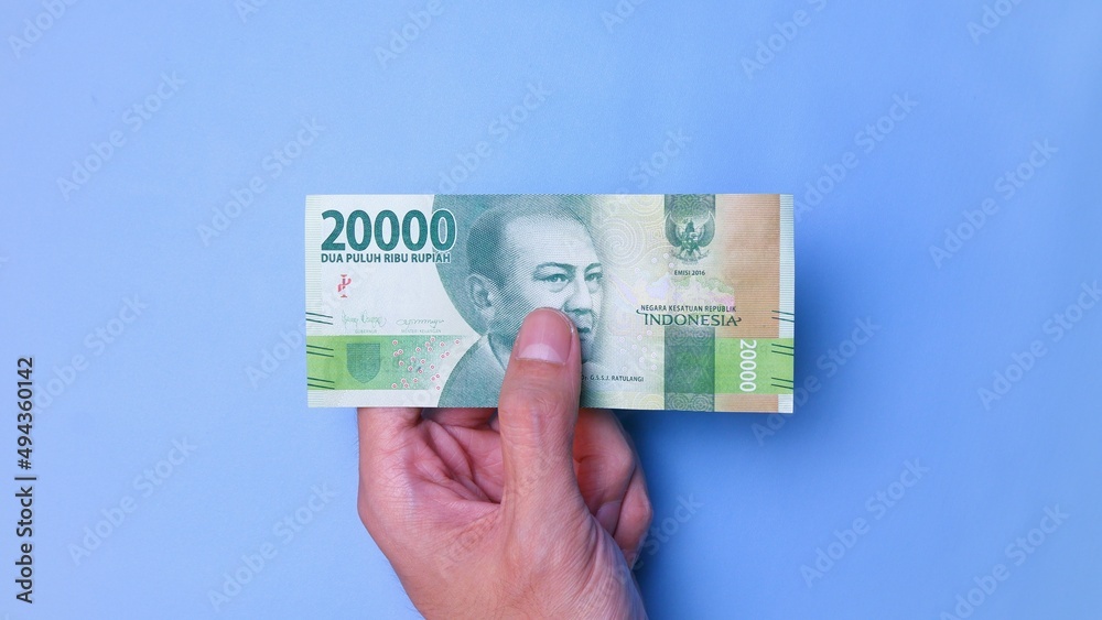 Indonesian Rupiah the official currency of Indonesia. Man's hand is ...