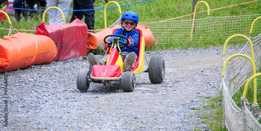 Foto de young boy rolling down hill in a go kart in the french alps at ...