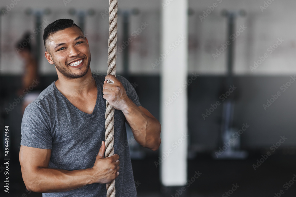 Im ready to conquer the rope. Cropped portrait of a young man climbing ...
