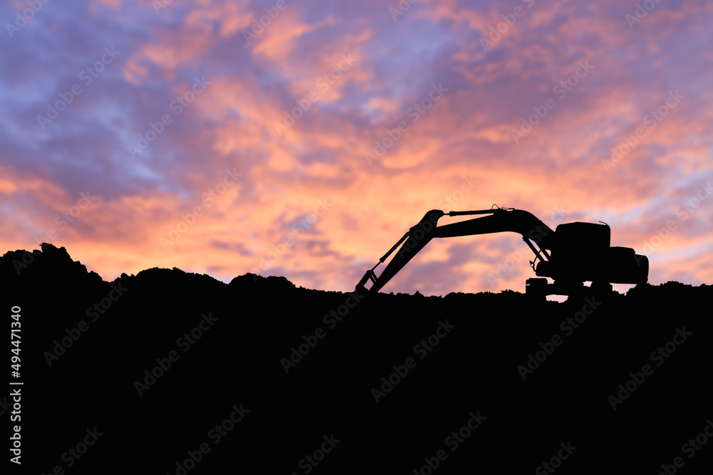 Excavators silhouette are digging soil with bucket lift up in the ...