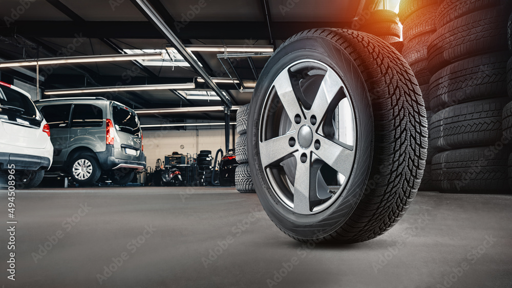 tire at repairing service garage background. Technician man replacing ...
