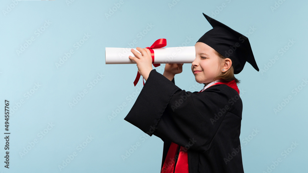Funny Whizz kid girl wearing graduation cap and ceremony robe on light ...
