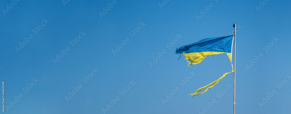 war in ukraine background. Destroyed Ukrainian flag in the wind ...