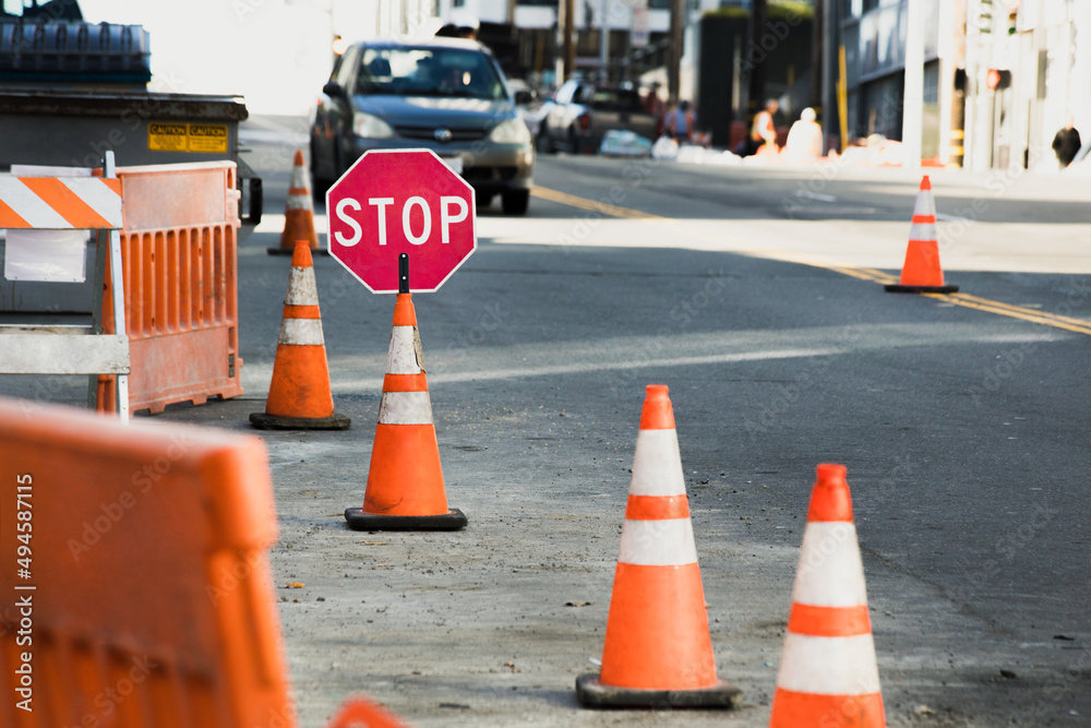 A warning stop sign and orange safety cones in an urban street. Signs ...