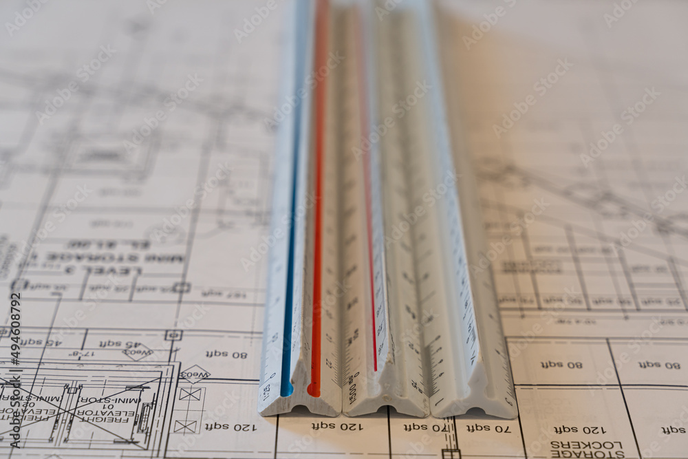 Architectural Scale Ruler with paper blueprints plans for new building ...