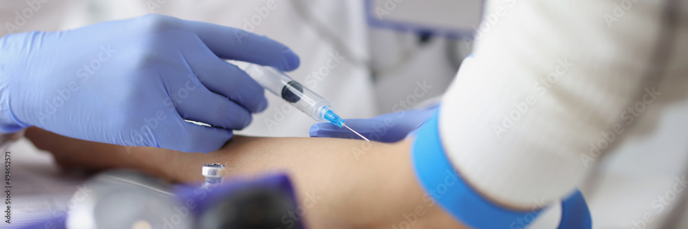 Nurse giving intravenous injection into patient ulnar vein at clinic ...