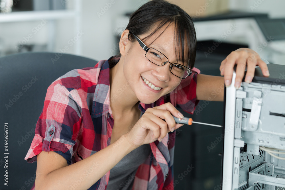 happy female pc technician fixing a desktop computer Stock Photo | Adobe Stock