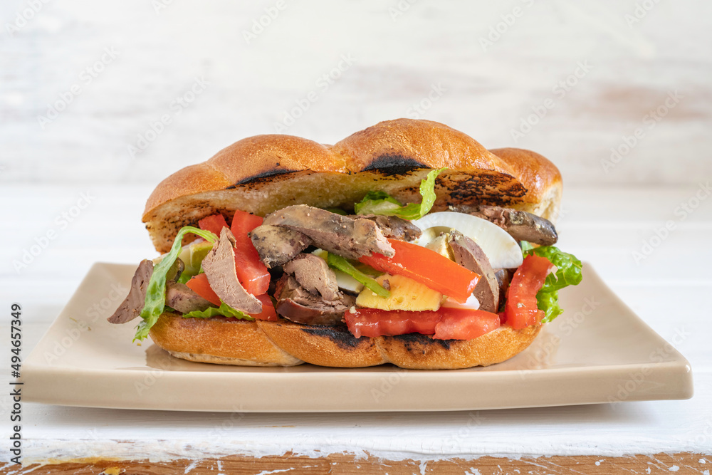 Challah sandwich with roasted liver, fresh tomatoes, boiled eggs on ...