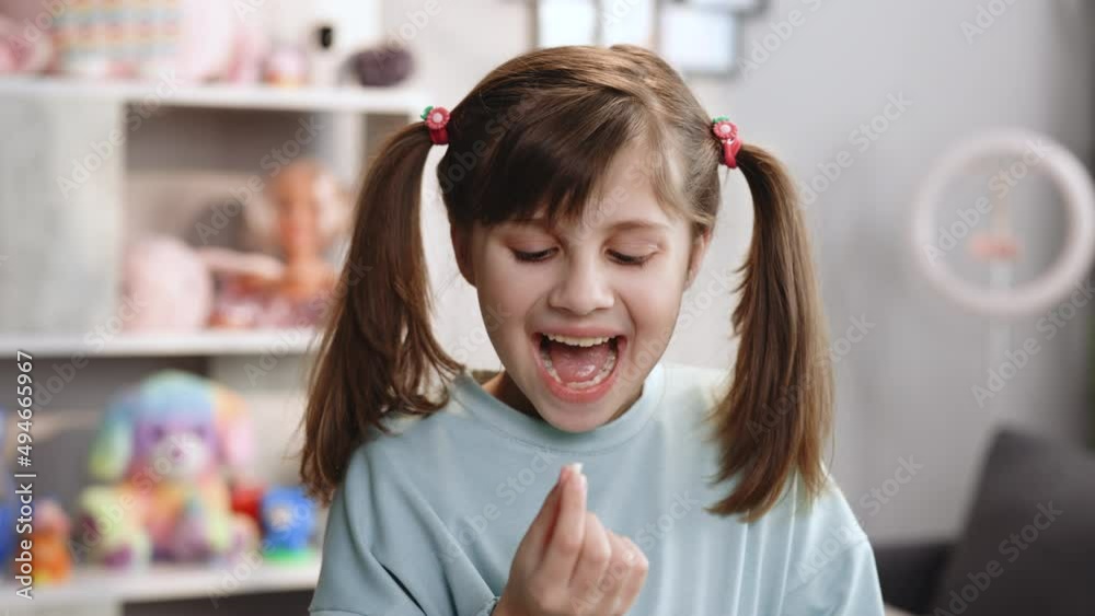 Stockvideon The child's milk tooth fell out. The pleased girl pulls out ...