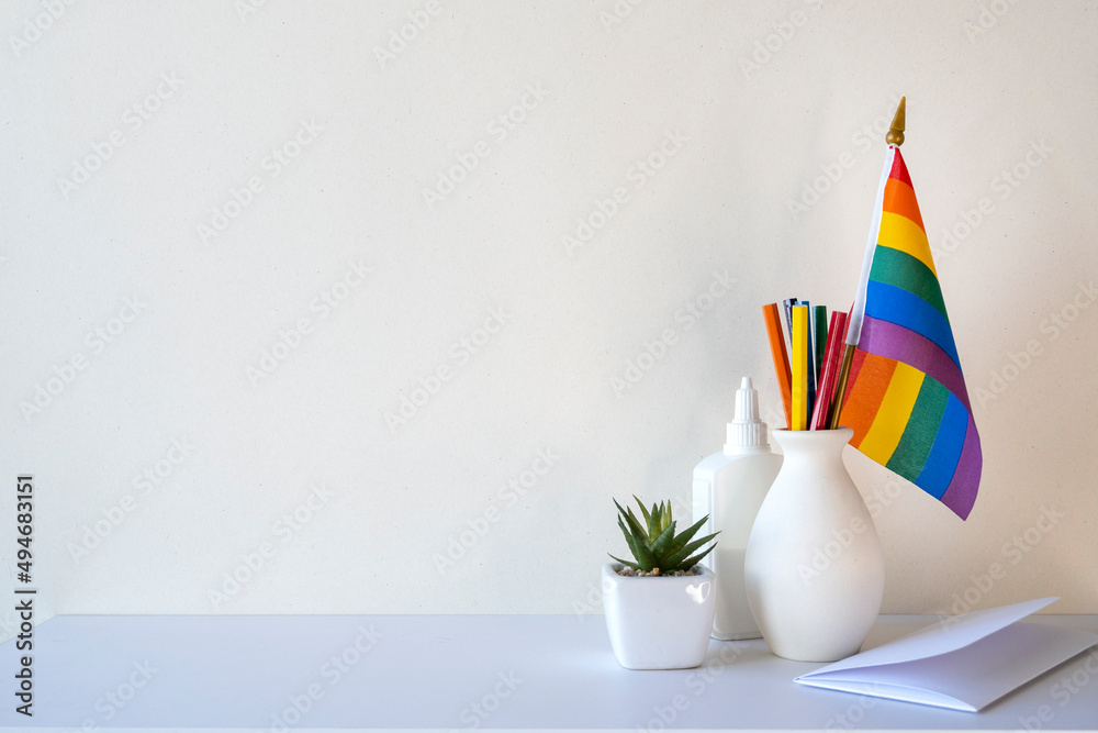 LGBT office, desk with rainbow flag and stationery, blank wall with ...