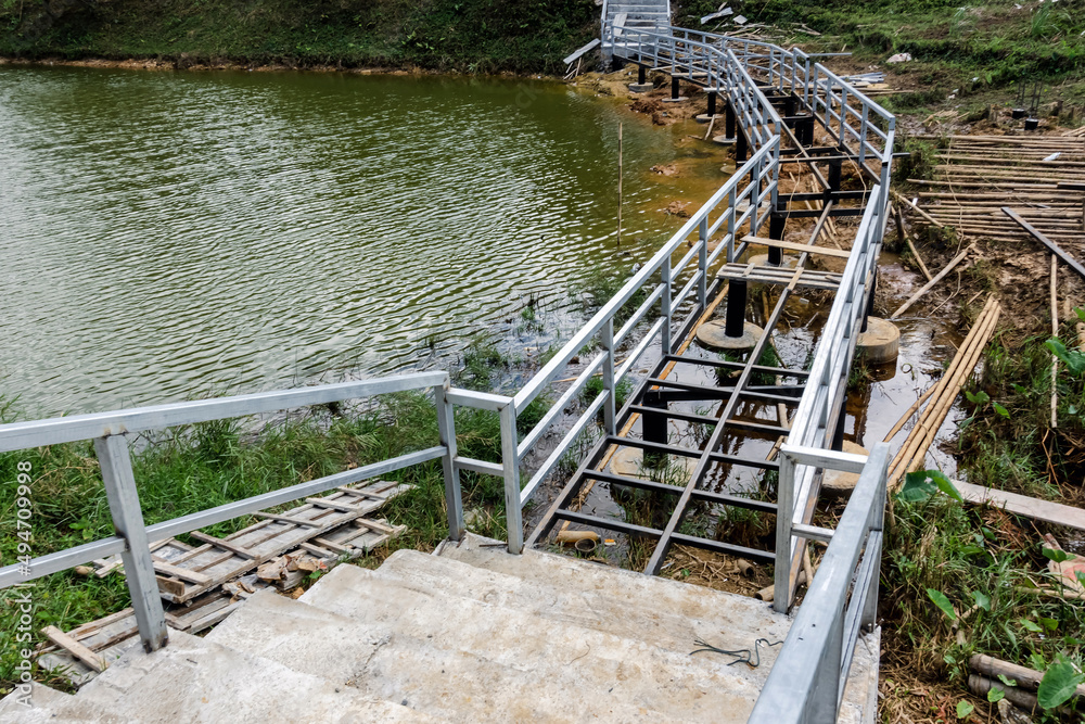 Construction of pedestrian bridge along the reservoir. The structure of ...