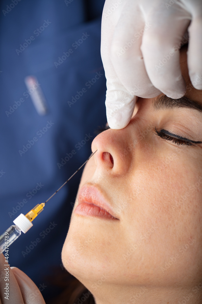 Female cosmetology in a beauty salon. Doctor nose tip correction and ...