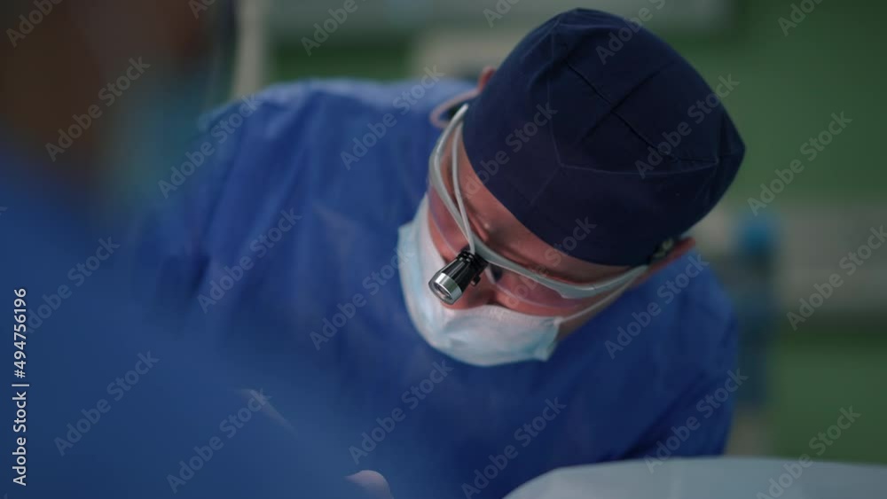 Close-up front view concentrated surgeon making dissection on face of ...