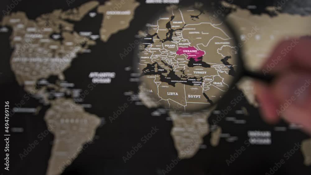 Ukraine on the world map under a magnifier loupe. Worldwide attention ...