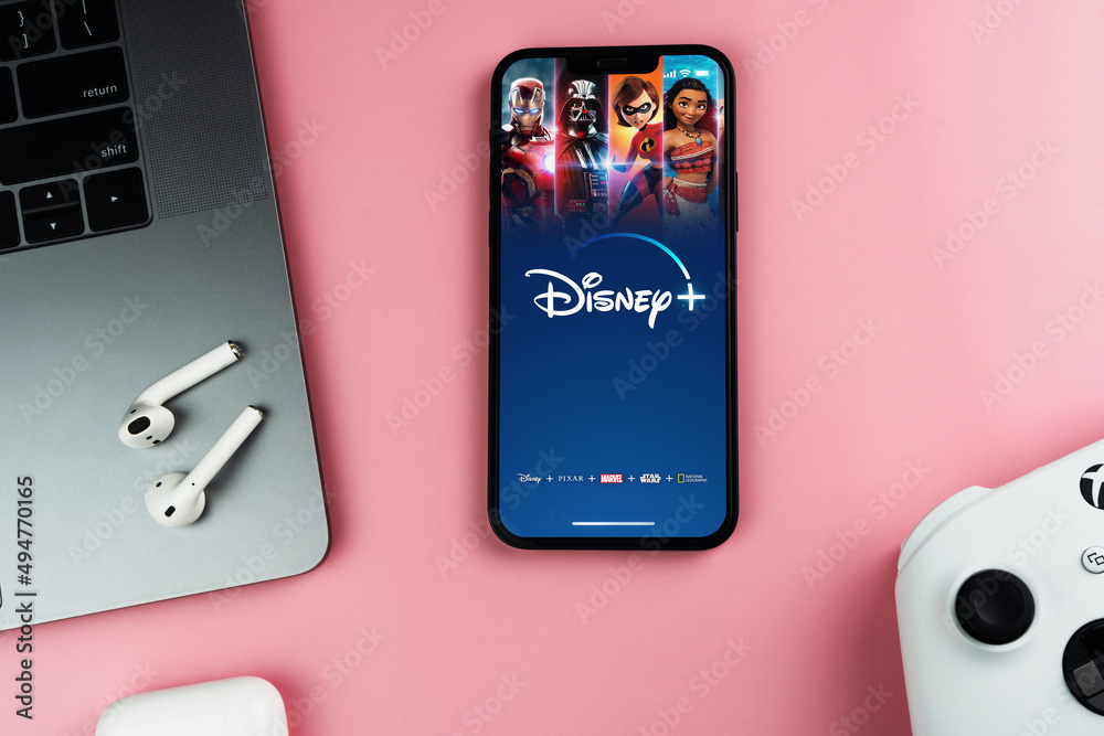 Disney+ (Disney Plus) app on the smartphone screen. Pink background ...