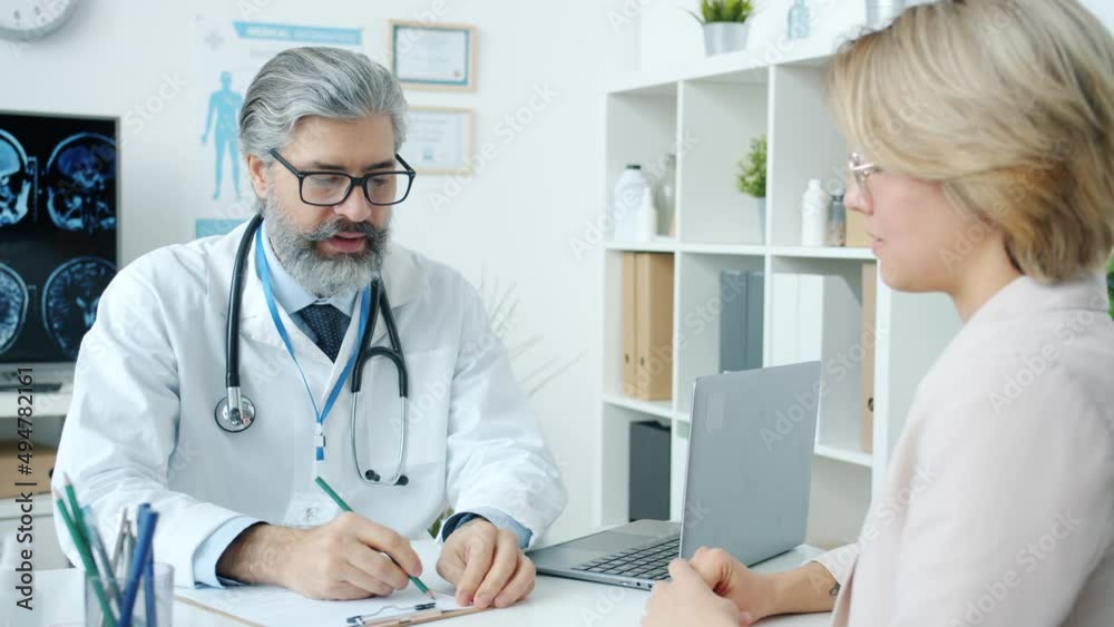 Doctor in white gown talking to young woman patient discussing ...