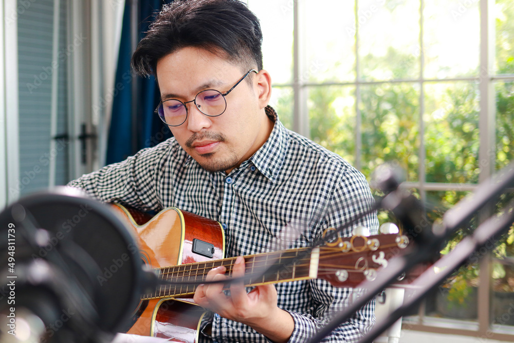 Asian musician artist Sit and play guitar in the studio. Music concept ...