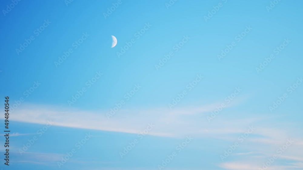 Dreamy scenery of half moon in sky during stunning sunset. Waxing ...