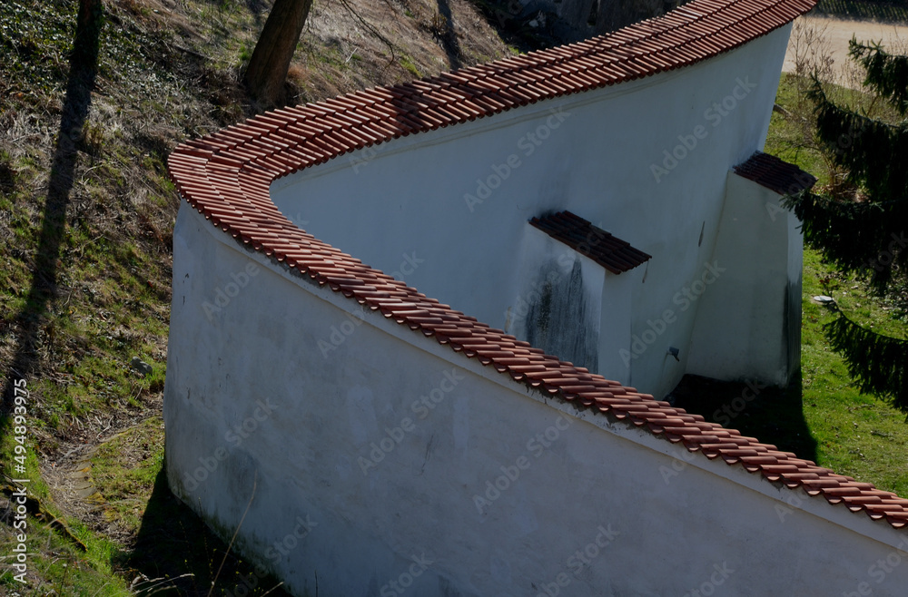 defensive wall of the castle with loopholes. zigzagging white wall with ...