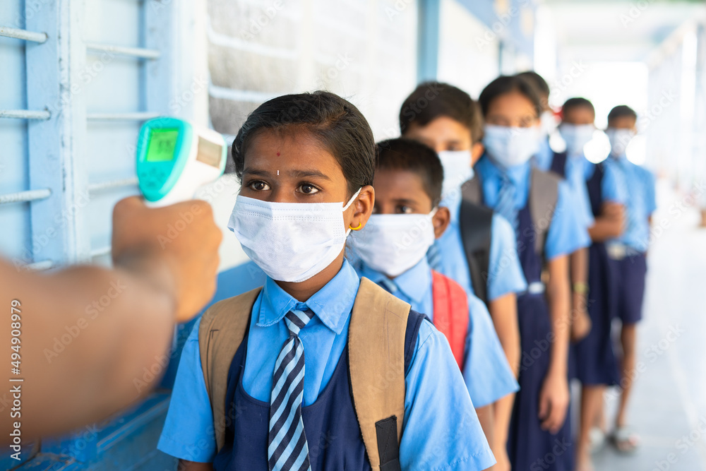 School kids with medical face mask being test with temperature before ...