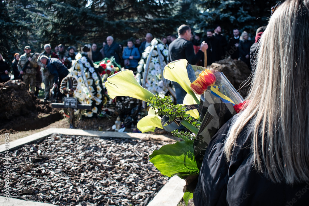 Girl holds Ukrainian mourning flowers. Funeral of the Ukrainian ...