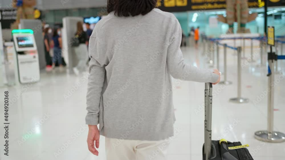 Woman holding hand luggage standing in the international airport ...