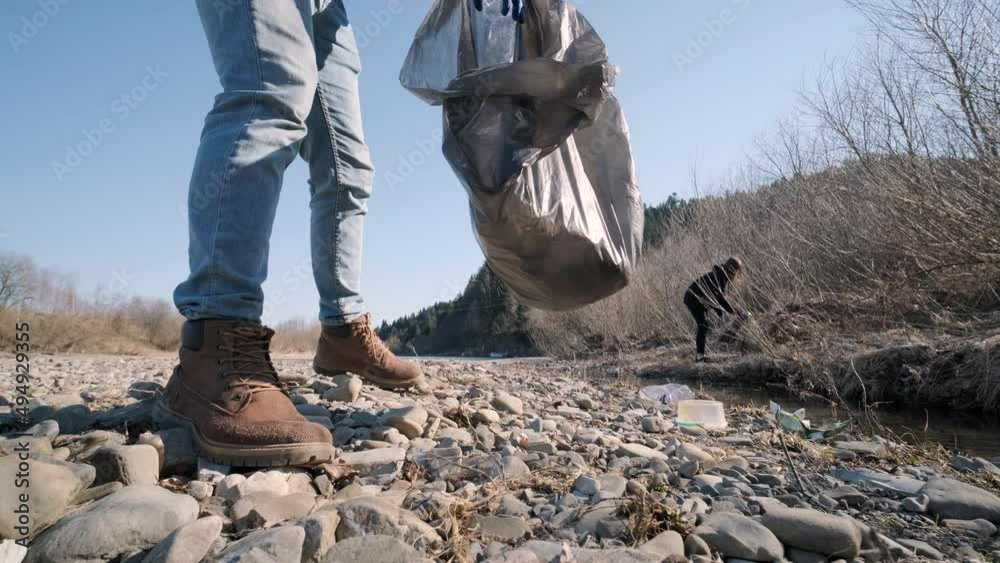 Teamwork cleaning plastic on the beach. Volunteers collect trash in a ...
