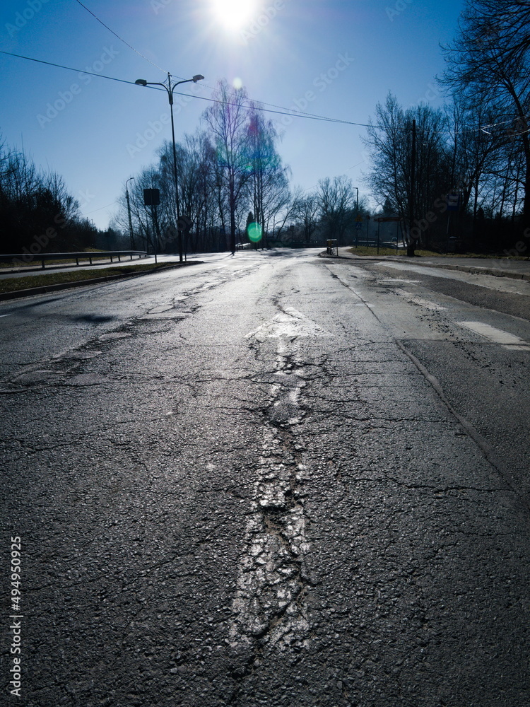 dilapidated asphalt hole road sign a traffic light hanging from the ...